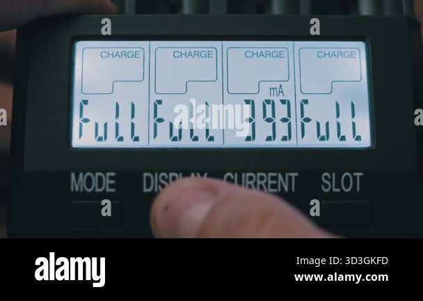 Macro view of a finger pressing the display button on a battery charger ...