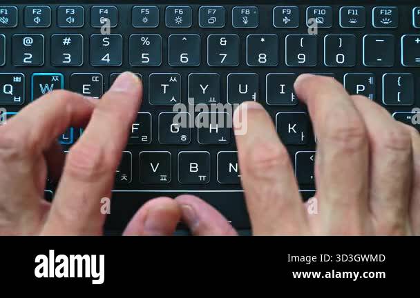 A close-up view of hands typing on a black keyboard with various ...