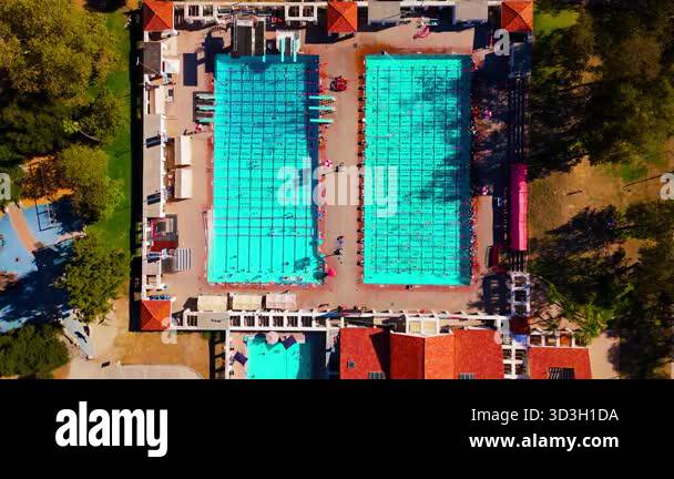 Drone top view of two large public swimming pools with lanes and people ...