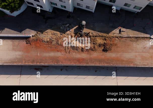 Aerial top down view of an excavator digging soil near residential ...
