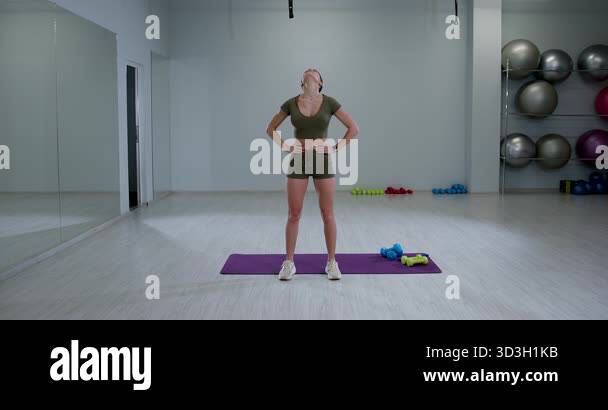 athletic woman performs head movements by bending her head forward and ...