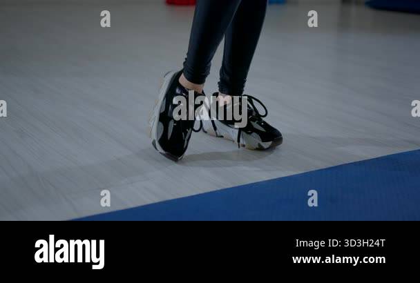 athletic woman in black leggings and sneakers is demonstrating the heel ...