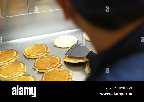 Flipping Korean Street Food Cheese Breads on Hot Griddle. A man flips ...