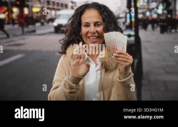 Woman smiling outdoors holding singapore banknotes with urban street ...