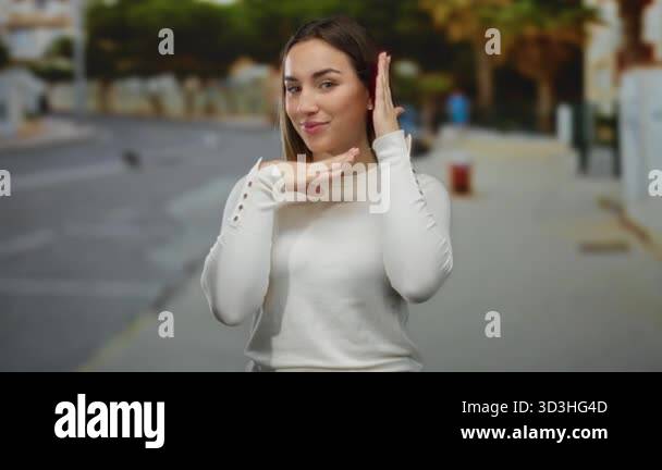 Woman gesturing with enthusiasm in an outdoor street setting ...