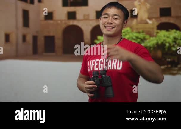 Man holding binoculars and pointing finger in building courtyard with ...