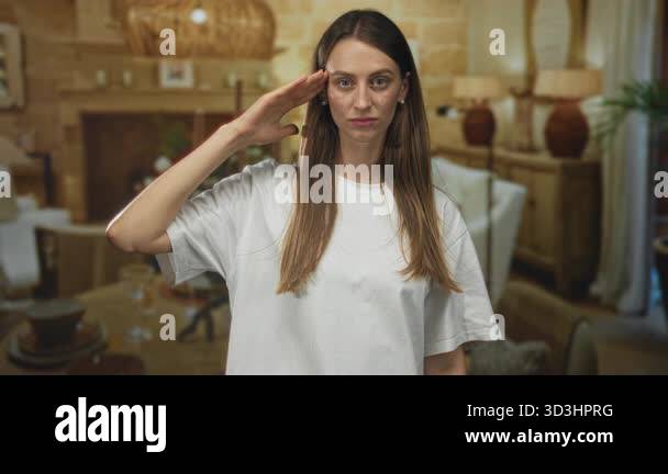 Young woman hand to forehead salute wearing white tshirt in building ...