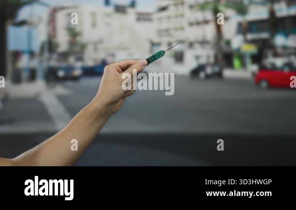 Man holding picklock on city street background, outdoors with traffic ...
