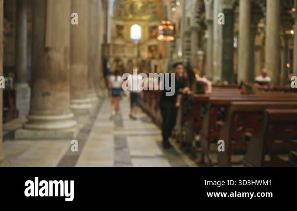 Blurry people walk inside a grand church with intricate architecture ...