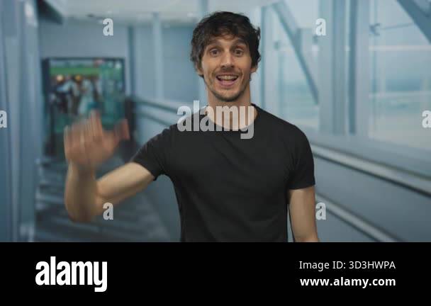 Man smiling with open mouth while waving hand and pointing fingers ...