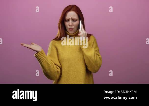 Woman with red hair in yellow sweater appears frustrated while talking ...