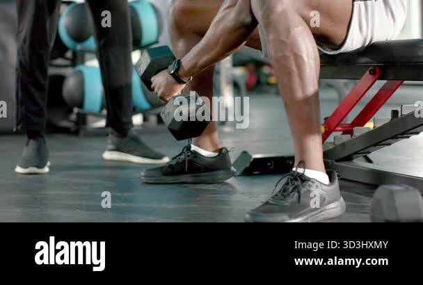 Gripping 10-pound dumbbell, African American man performing preacher ...