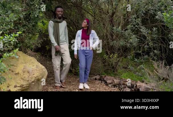 Spotting clearing Diverse couple walking forest path carrying log ...