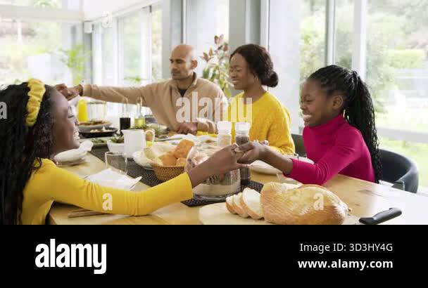 Gathering around table Diverse family holding hands, bowing heads and ...