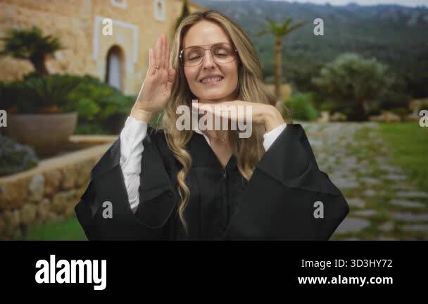 Young blonde woman judge wearing uniform poses in old town street ...