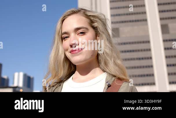 Noticing camera, woman in light green jacket lifting smile into broad ...