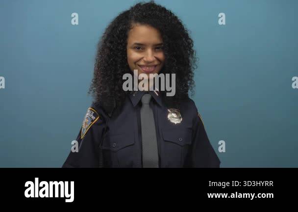 Woman police officer in uniform raising finger salute to head against a ...