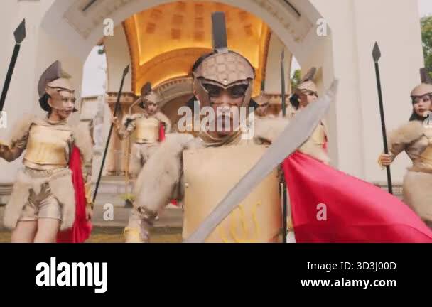 A group of soldiers in golden armor walked together down the steps of ...