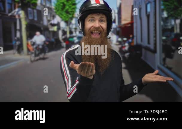 Man wearing helmet gestures with open hands on busy street under bright ...