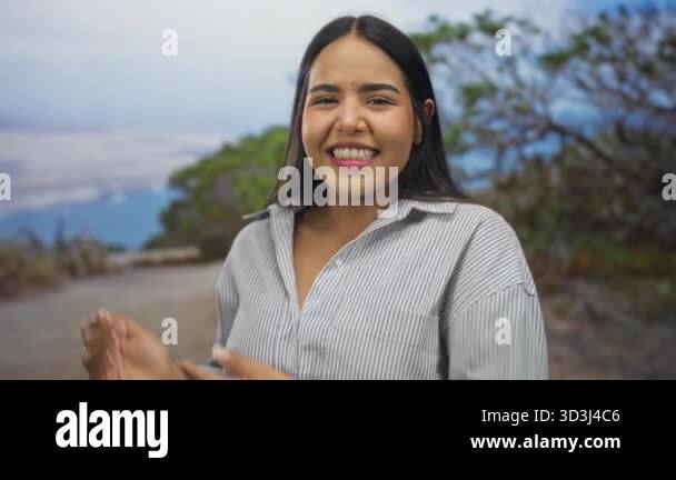 Young woman smiling in a scenic park with vibrant greenery, capturing a ...