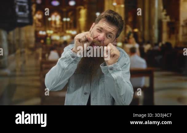 Bearded man mimics crying gesture inside grand church building with ...