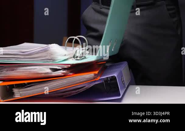 Persons hand opening a ring binder to insert or remove punched ...