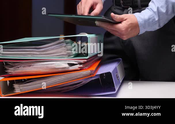 Businessman holding a tablet while comparing digital data to colorful ...