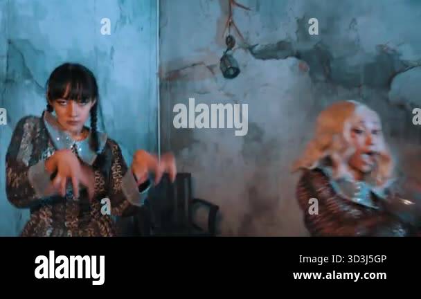 A medium shot, zooming in, of two women (one gothic, one blonde) in ...