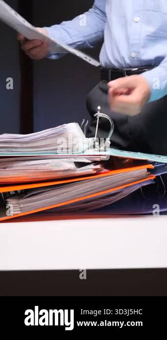 vertical video Persons hand opening a ring binder to insert or remove ...