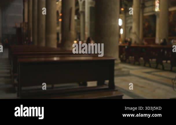 Blurry church interior with wooden benches and tall columns creating a ...