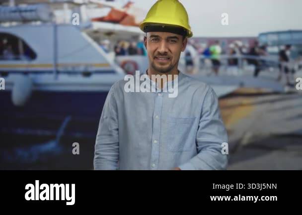 Young hispanic man wearing hardhat at seaside port making refusal ...