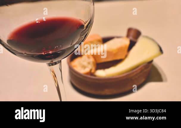 Close-up of a red wine glass and tapas plate with bread and cheese ...