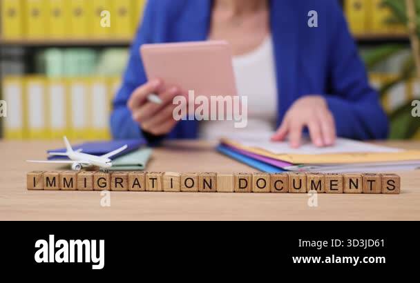 Organized workspace shows a person preparing immigration papers ...