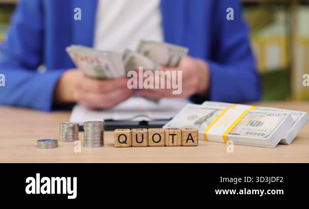 A person is carefully counting various bills and coins at a bright desk ...