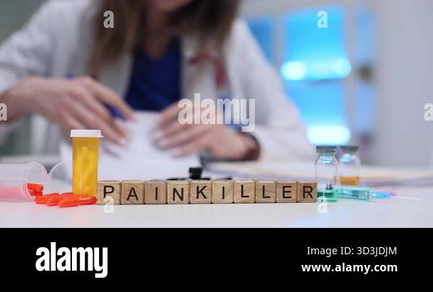 Woman reviews papers near Painkiller on blocks and colorful pills on ...