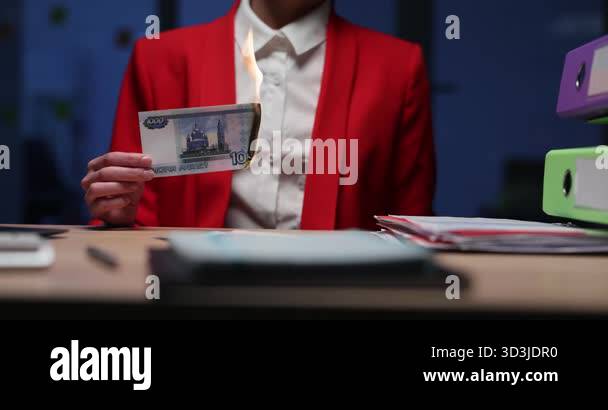 Businesswoman holds burning Russian banknote highlighting financial ...