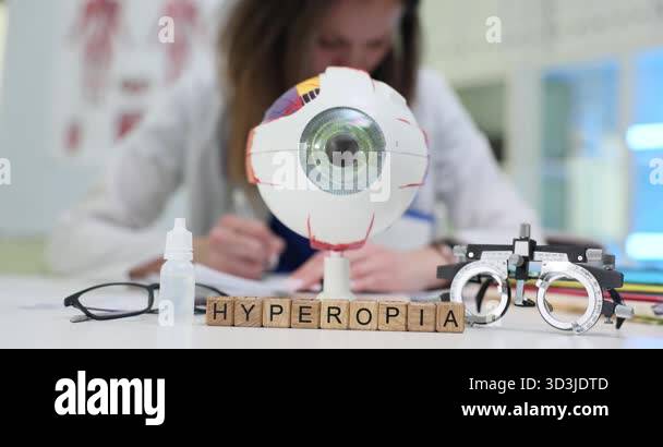 Woman works at desk with Hyperopia on blocks eyeball model and ...