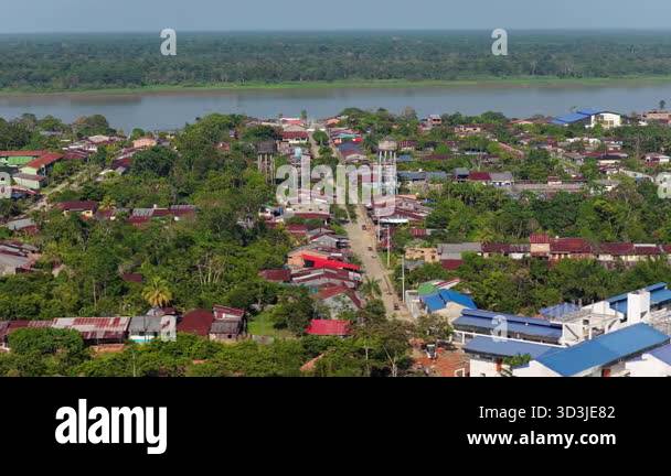 Aerial perspective of a small Amazonian village nestled along the ...
