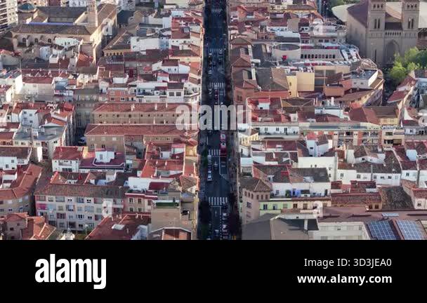 Unique aerial perspective flying over a long straight street in the ...