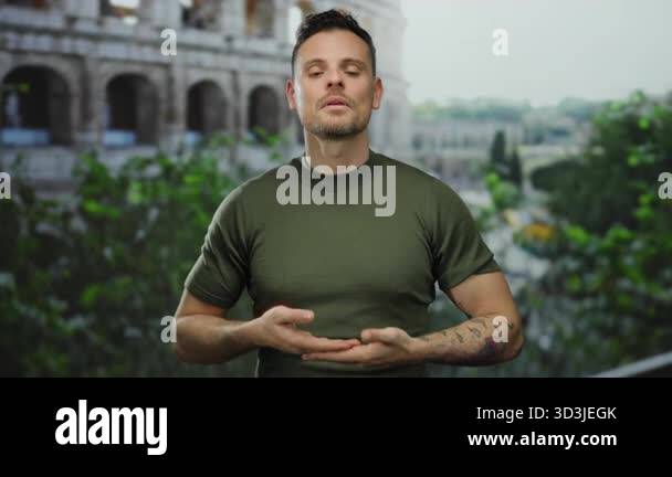 Young man meditating outdoors near the roman coliseum, displaying a ...