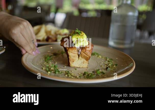 Woman's hand reaching for a gourmet dish in a restaurant setting, with ...