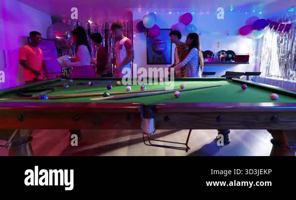 Eager for Dream Mania, Diverse friends around pool table carrying game ...