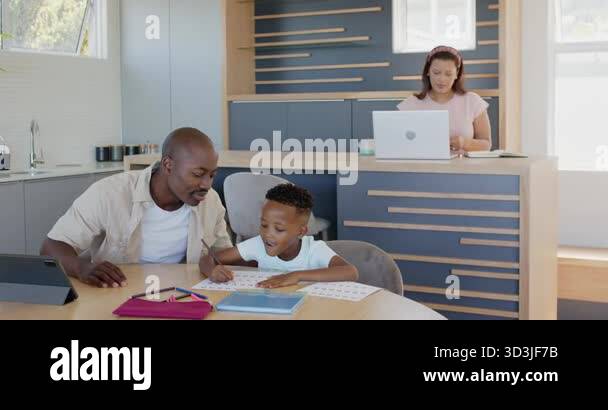 African american father helping son with homework at kitchen table ...