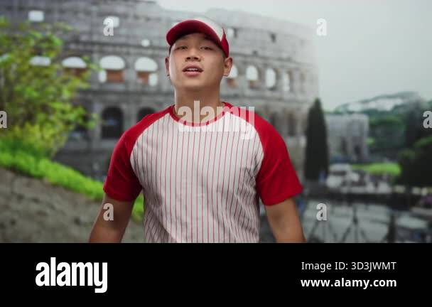 Young chinese man in a baseball uniform smiling confidently near the ...