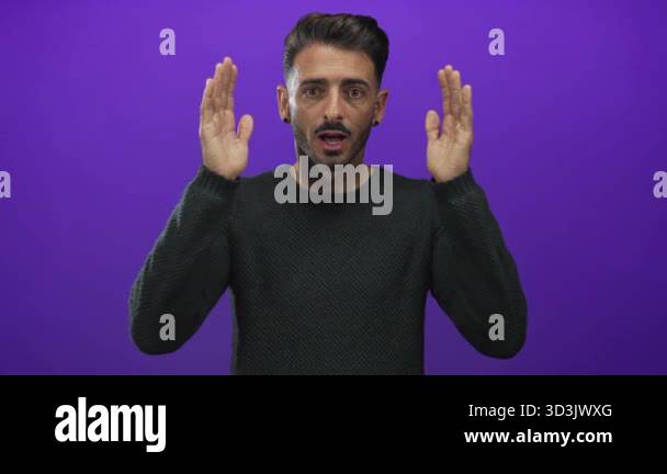 Man raising hands with open mouth in studio, palms facing forward ...