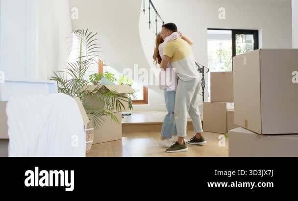 Happy man and his partner moving into new home., dancing and smiling ...