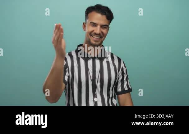 Young hispanic male referee offers handshake confidently against a ...