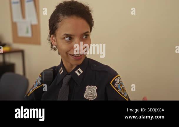 Hispanic woman police officer in uniform smiles confidently inside a ...