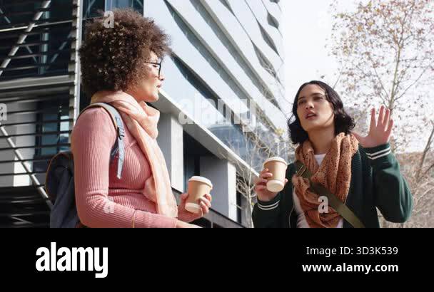 Diverse female friends holding coffee cups, right friend starting ...