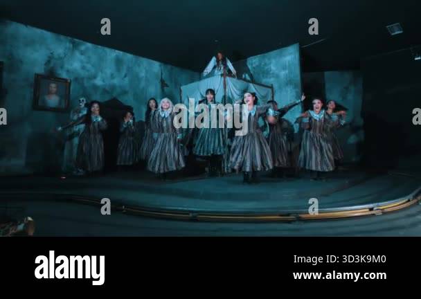 A group of young women in vintage dresses performs a synchronized ...